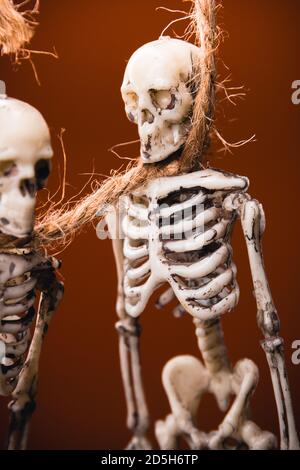 Fake skeleton on a rope in the background on an orange background ...