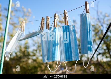 Sunlit face masks are hung to dry for disinfection fastened by wooden ...