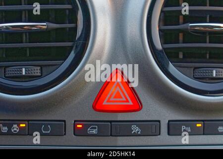 Illuminated red hazard safety triangle button in vehicle Stock Photo ...