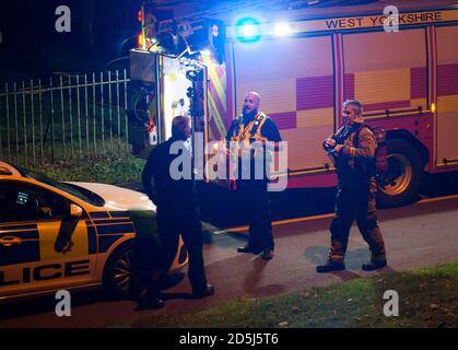 UK police officer liasing with the fire brigade at a emergency scene.A ...