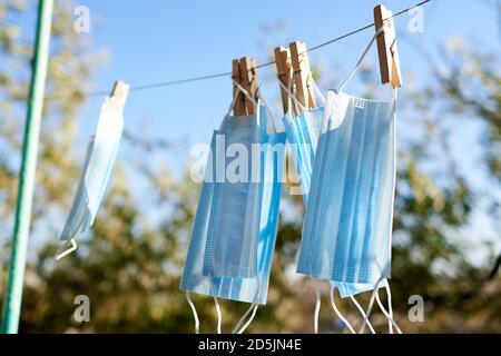 Sunlit face masks are hung to dry for disinfection fastened by wooden ...