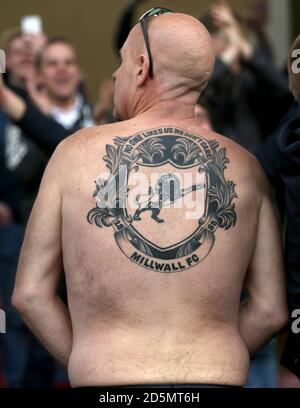 A Millwall fan with a large club tattoo on his back celebrates victory ...
