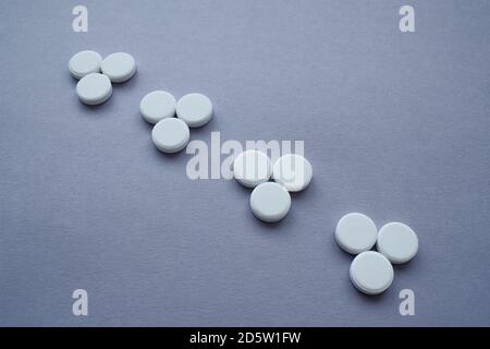 Round medicinal pills in the form of three triangles arranged in a row ...