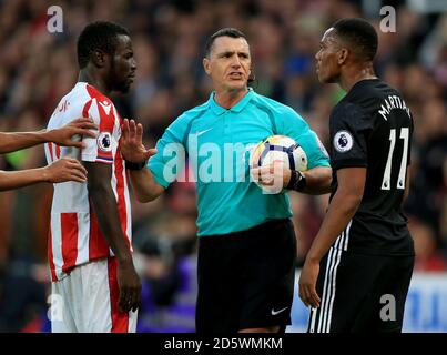 Referee Neil Swarbrick (centre) speaks to West Ham United goalkeeper ...