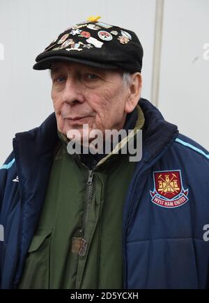 A West Ham United fan with badges and a poppy on his hat before the ...