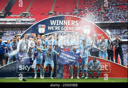 Coventry City players celebrate with the trophy on the podium after the ...