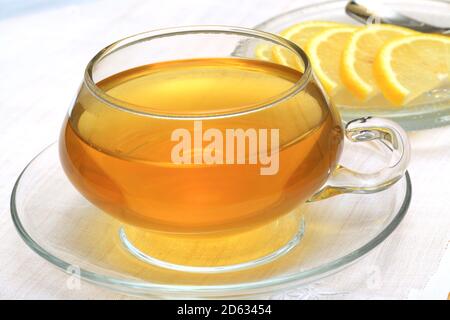 Glass cup of black tea, ginger roots, anise and cinnamon on wooden ...
