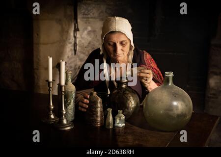 Woman in medieval outfit working as an alchemist or witch in the ...