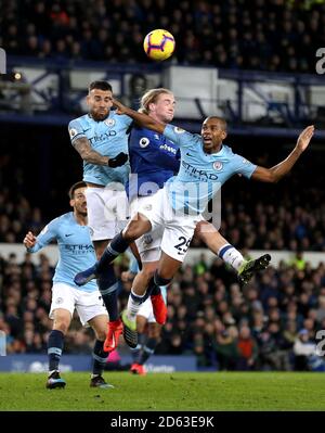 Everton's Tom Davies (centre) battles for the ball with Arsenal's ...