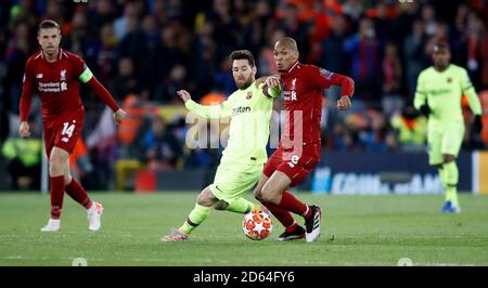 Liverpool's Fabinho (left) and Barcelona's Lionel Messi (back) battle ...