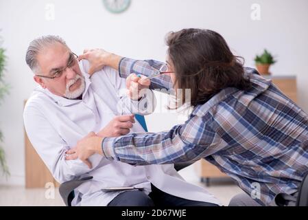 Young psychopath and experienced doctor in madhouse Stock Photo - Alamy
