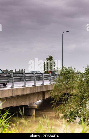 bridge on muddy water of a raging river Stock Photo - Alamy