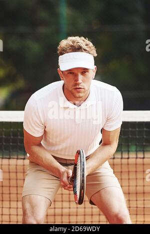 Young tennis player in sportive clothes is on the court outdoors Stock ...