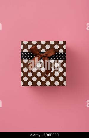 Brown gift box on the pink background with christmas decoration ...