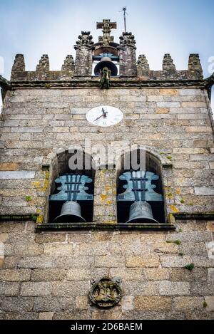 A clock tower with bells and a large clock on a historic castle ...