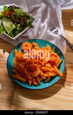 Penne alla vodka with shrimp and side salad Stock Photo - Alamy