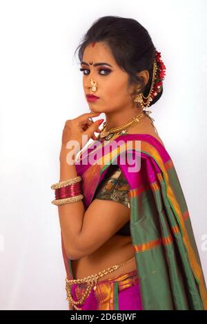 Indian model dressed in Maharashtrian bridal wear with orange Sari. Looking at camera. Hands in ...