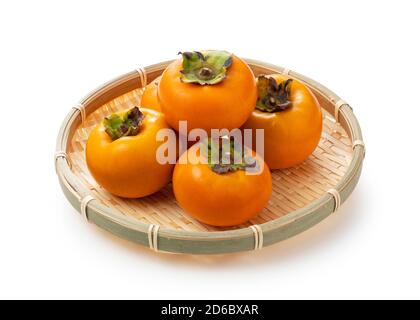 Japanese persimmon in a colander on a white background Stock Photo - Alamy
