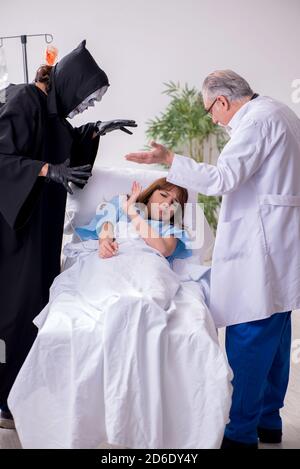 Devil, old doctor and female patient in clinic Stock Photo - Alamy