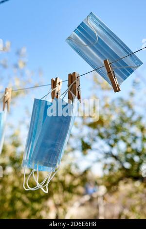 Sunlit face masks are hung to dry for disinfection fastened by wooden ...