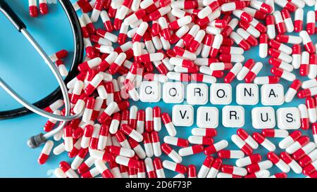 Closeup shot of "Coronavirus" cubic letters, capsule medications, and a ...
