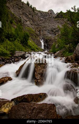 Small waterfalls streaming in green forest in long exposure. water in ...