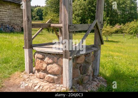 Stone well with a wooden roof and a bucket of water in beautifully ...
