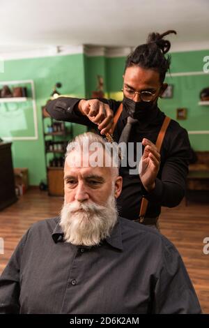 Young man hairdresser in mask cleaning floor in the beauty salon Stock ...