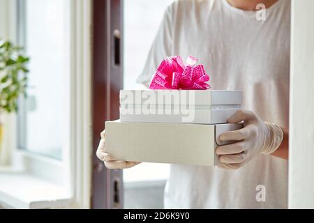 Courier man contactless delivery presents, gift box during a ...