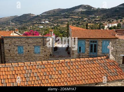 Traditional Cypriot houses with red tiled roofs and a white minaret of ...