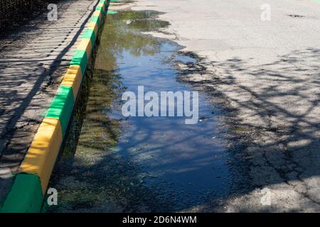 Large puddle on asphalt. Road with pits. Puddles on road. Rural highway ...
