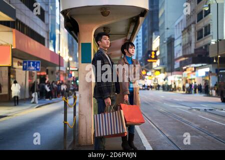 Trendy young Japanese woman waiting for the bus with umbrella. Kyoto ...