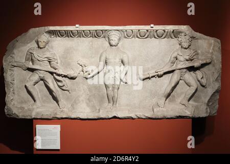Relief depicting a cult statue of Apollo standing between two torch ...