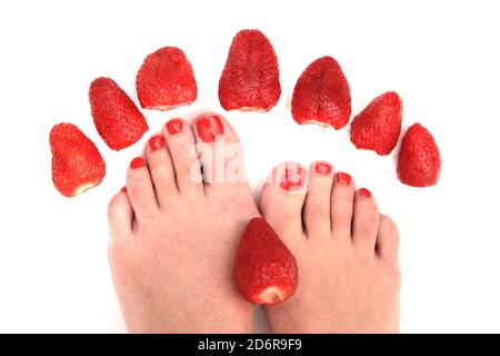 women feet (pedicure) with strawberries isolated on the white ...
