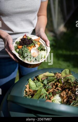 Woman composting food leftovers at home. Female recycling organic waste ...
