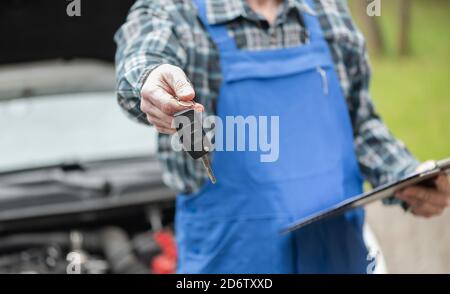 Car mechanic delivering car keys after car engine checking; multiple ...