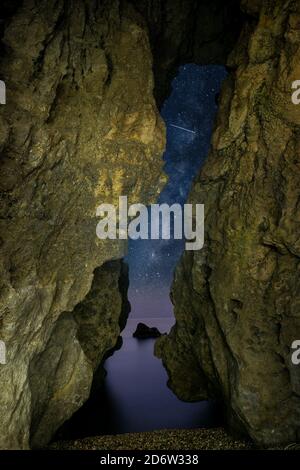 A beautiful view of a rock in the sea from a tree Stock Photo - Alamy