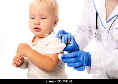 Selective focus of pediatrician in latex gloves holding cotton near hand of toddler isolated on white Stock Photo Alamy