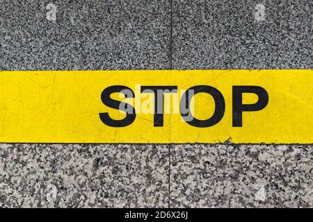 Stop sign yellow line at marble floor warning Stock Photo - Alamy