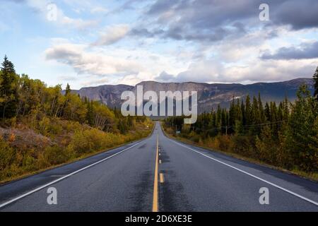 the view of the cloudy sky, trees, mountains and houses photographed ...