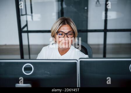 Female stockbroker in formal clothes works in the office with financial ...