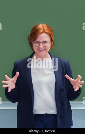 A female teacher with a face red with rage. Angry teacher yells at the ...