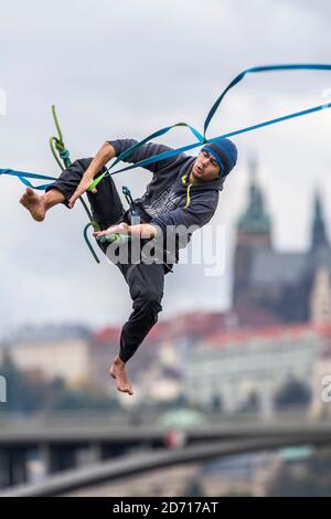 a tightrope walker falling off from slack line above the Vltava river ...