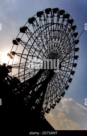 Sun shines through a ferris wheel Stock Photo - Alamy