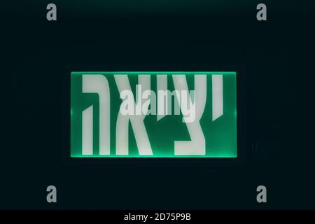 Exit sign in Hebrew, green signage showing the way to exit in an aged ...