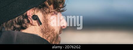 Wireless earbuds man walking running in a field listening to music with ...