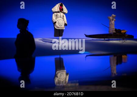 A staff member walks at an Amauti, a parka with a baby carrier built ...