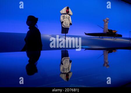 A staff member walks at an Amauti, a parka with a baby carrier built ...