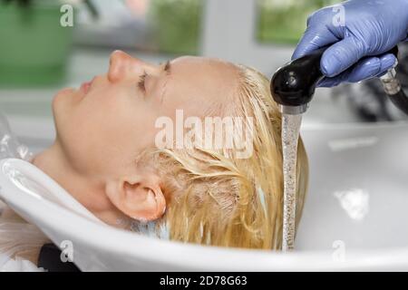 Hairdresser, beauty salon and people concept - young woman hair stylist ...