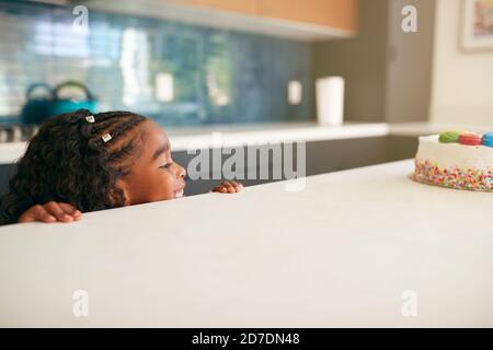 Girl Hiding Behind Kitchen Counter Takes Sneaky Look At Birthday Cake ...